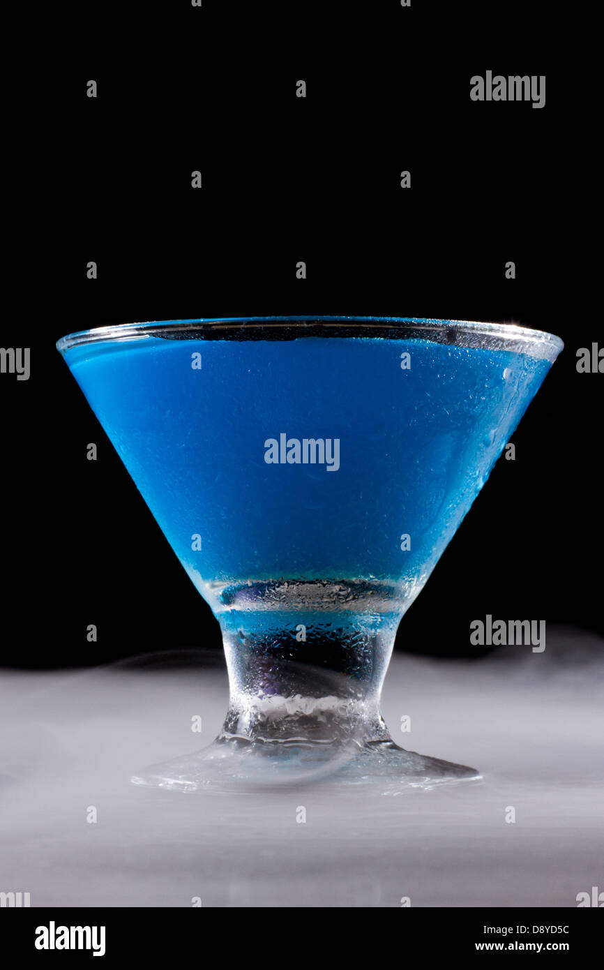 small bright blue cocktail on a dark foggy dramatic bar Stock Photo - Alamy