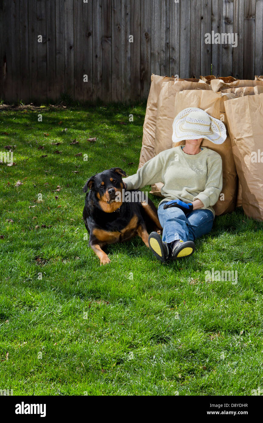 woman and her dog taking a break after cleaning up the back yard Stock ...