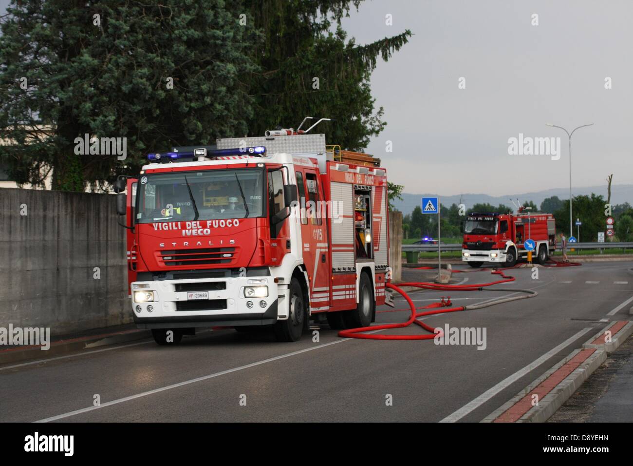 firefighters in action with the fire truck to extinguish the fire in a ...