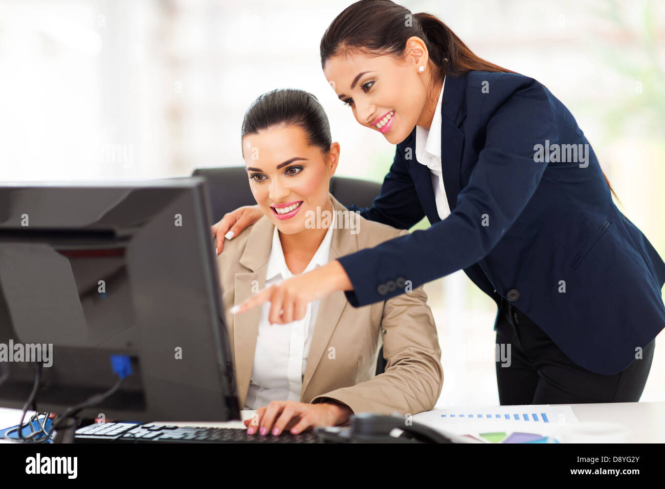 cheerful two business women working at the office on a computer Stock ...