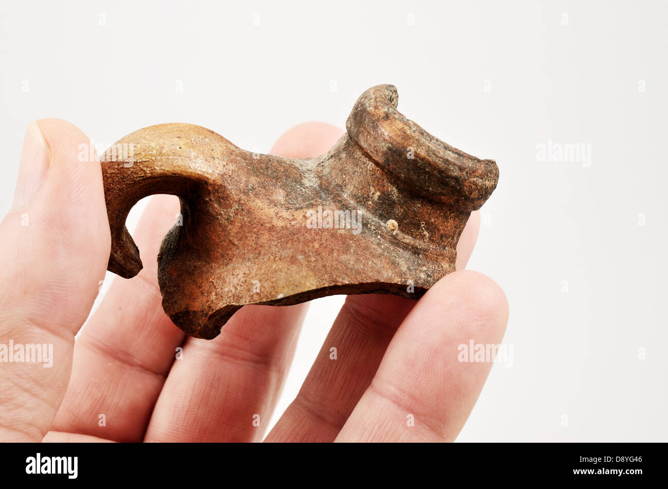 hand holds an potsherd over a neutral background Stock Photo - Alamy