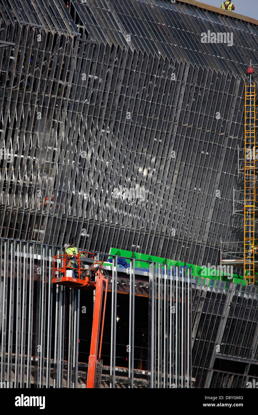 People on lift outside steel arena structure in progress Stock Photo ...