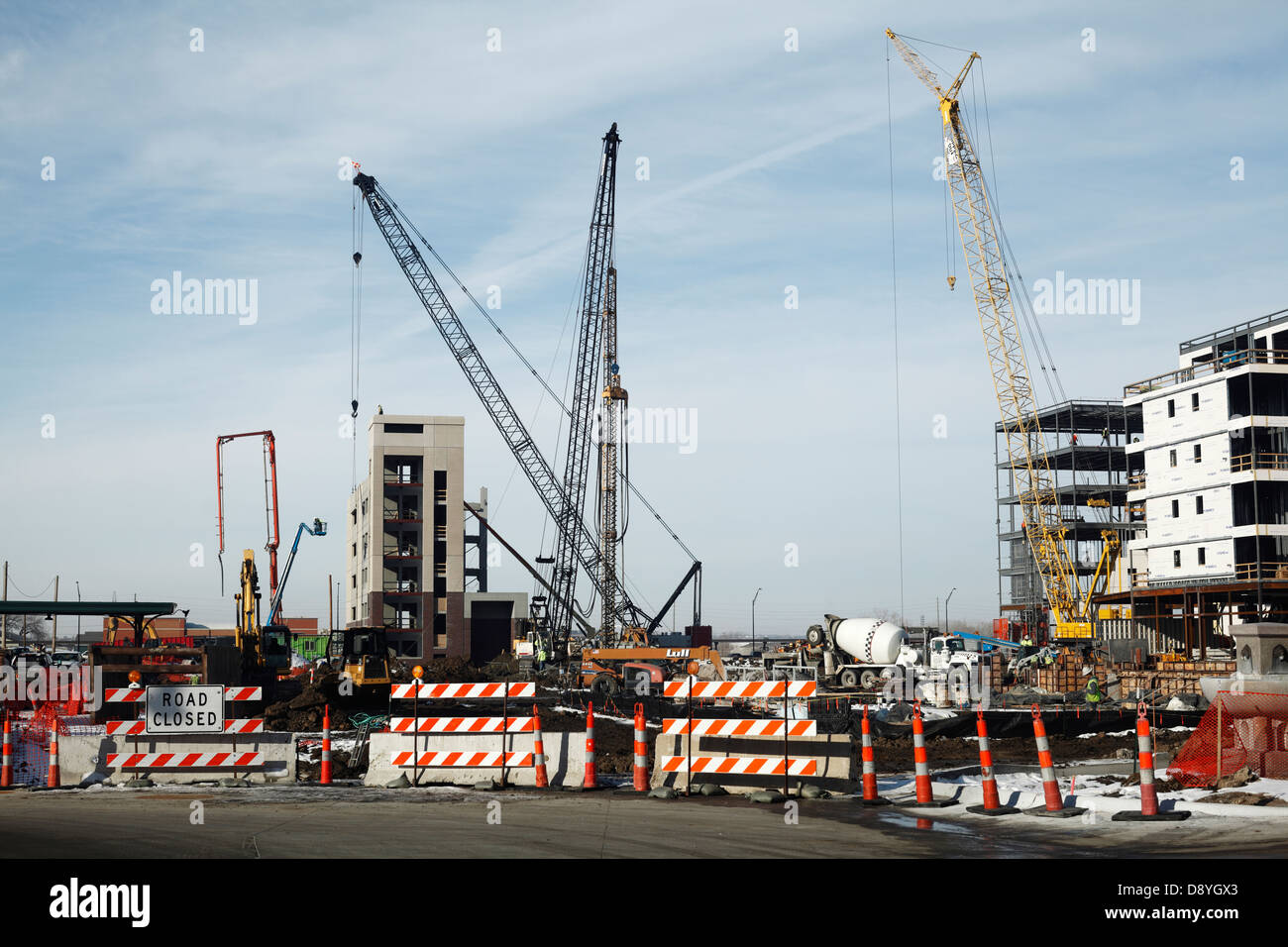 Job site with 3 cranes beyond road barriers Stock Photo - Alamy
