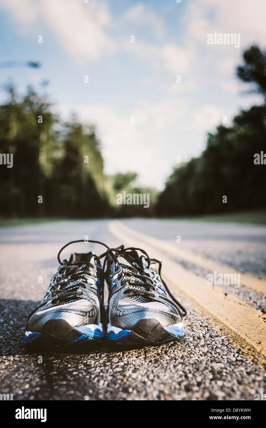 Lone pair of new running shoes, just waiting to be used on an open road ...
