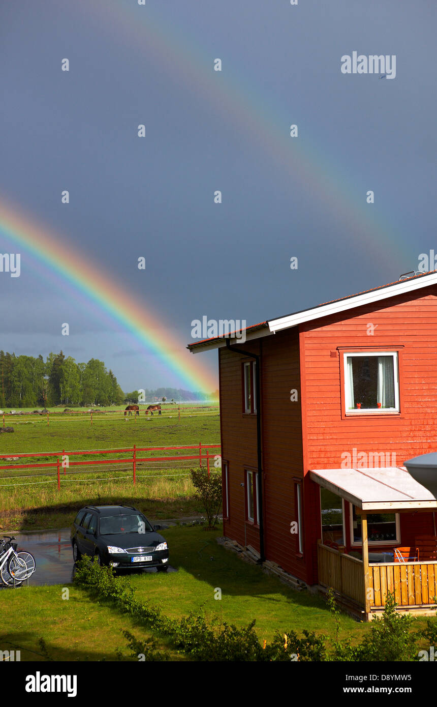 Rainbow over houses, Sweden Stock Photo - Alamy