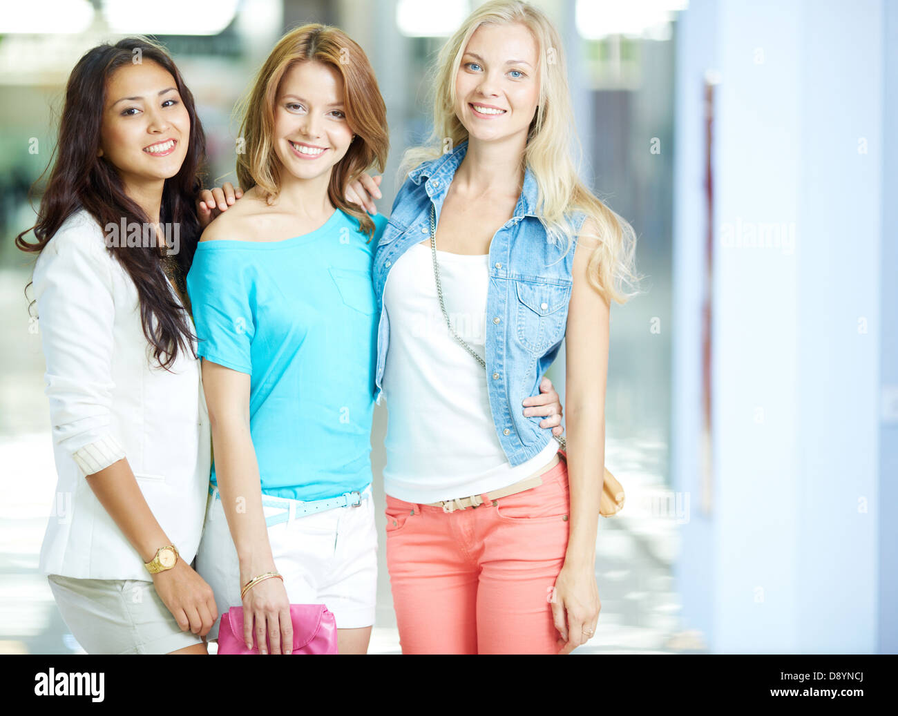 Portrait of three happy girls in smart casual looking at camera Stock ...