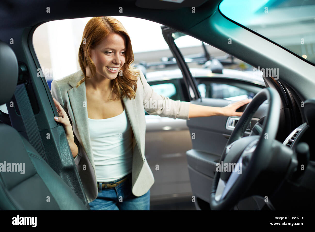 Photo of elegant woman choosing a new car in automobile center Stock ...