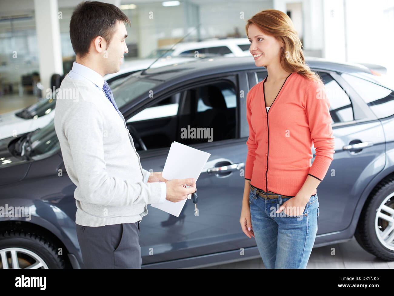 Image of car dealer and happy female communicating in automobile center ...