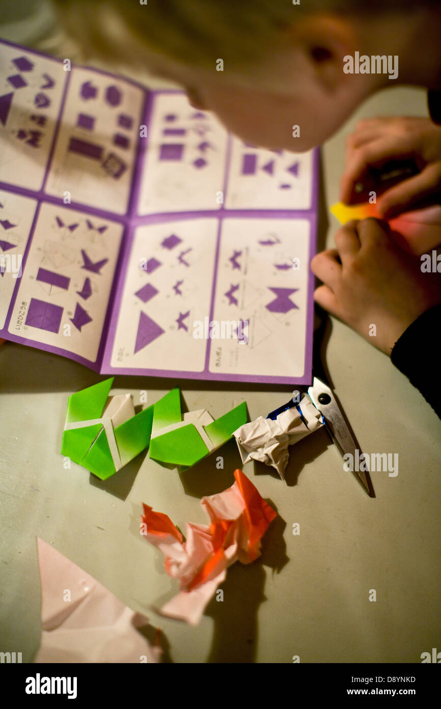 Boy doing origami Stock Photo - Alamy