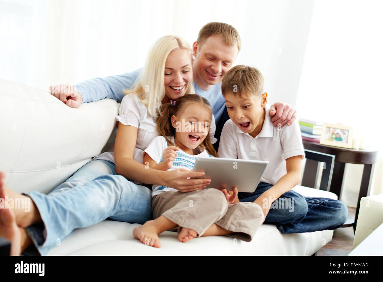 Portrait of ecstatic family with two children looking at something ...