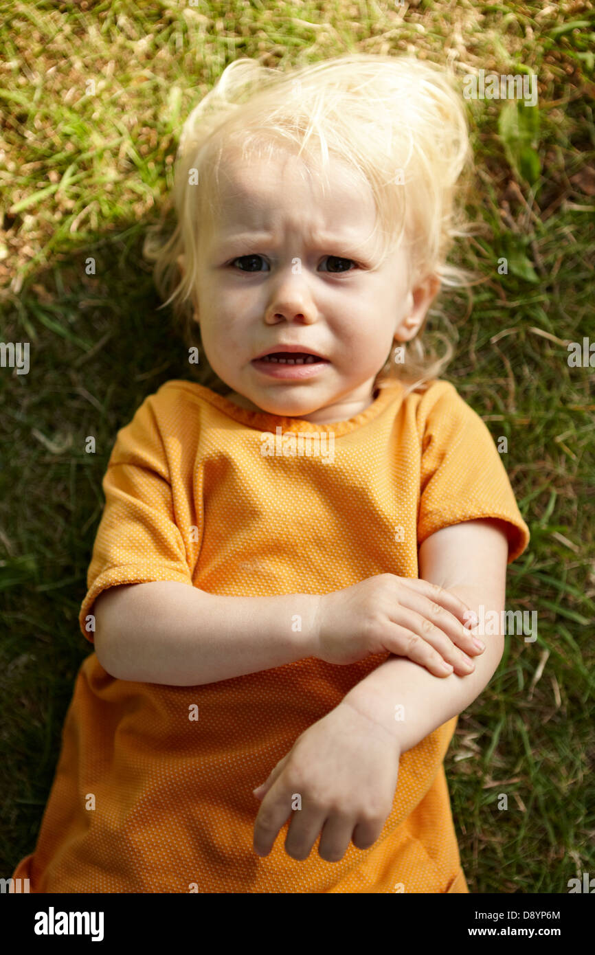 Girl lying on grass, crying Stock Photo - Alamy