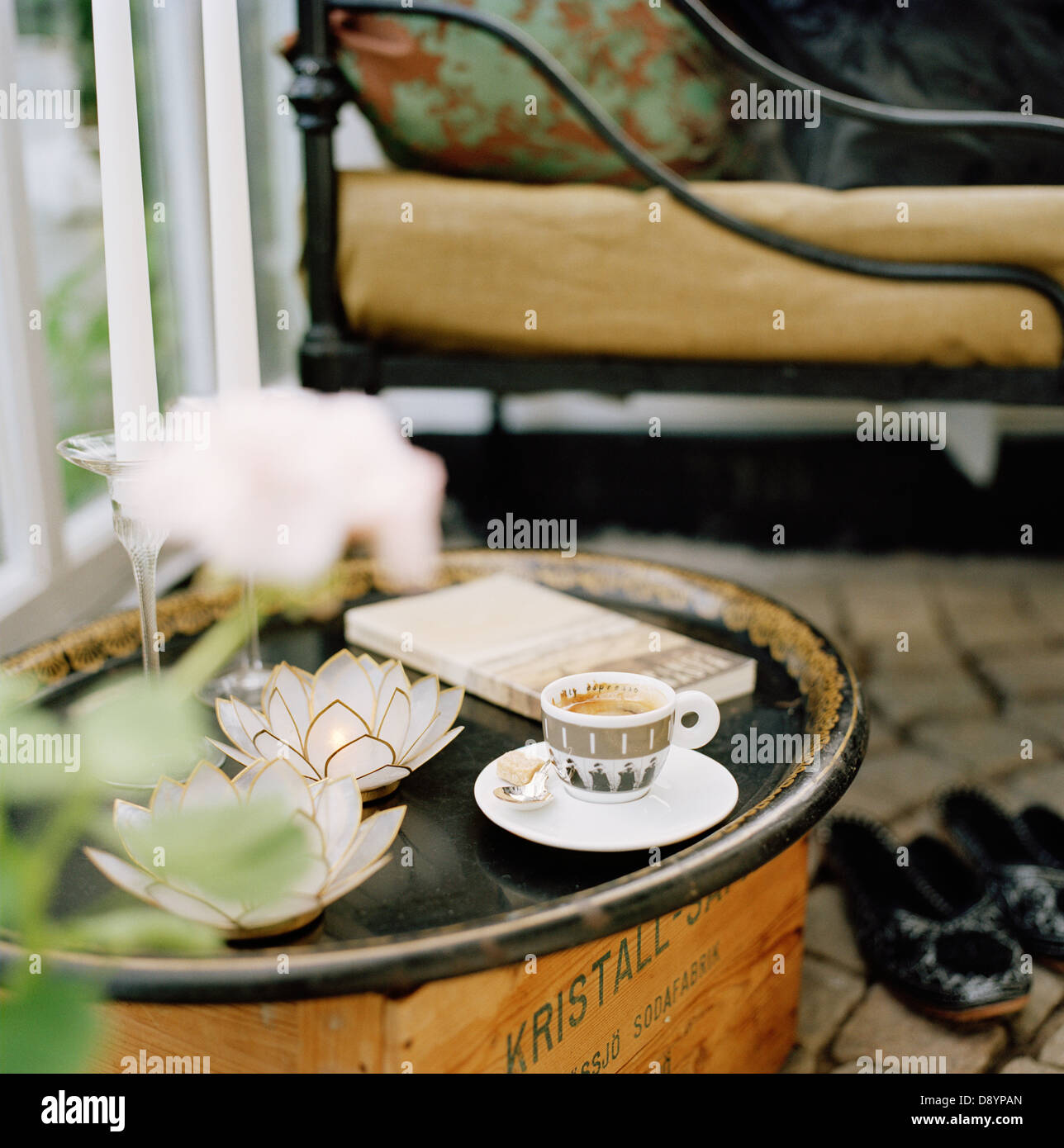 Coffee pot on table with book and tea lights Stock Photo - Alamy