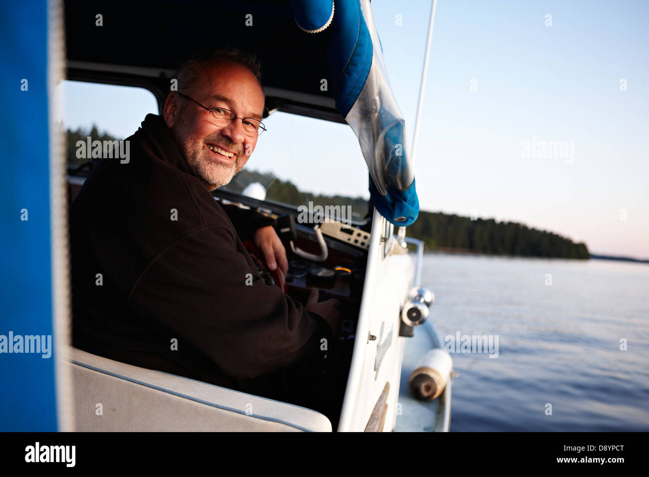 Man driving boat, smiling Stock Photo - Alamy