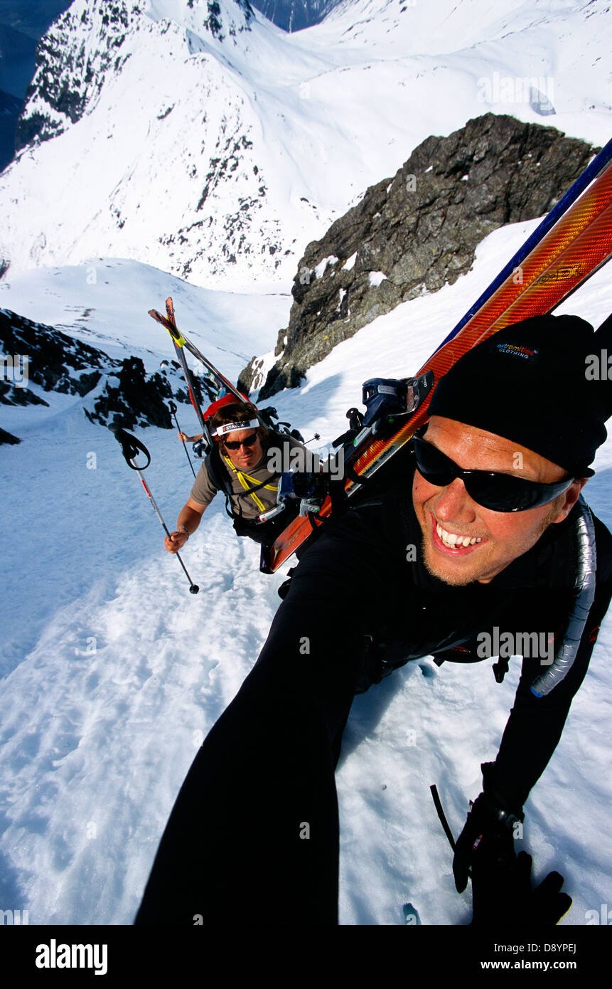 Two mountain climbers carrying skis Stock Photo - Alamy