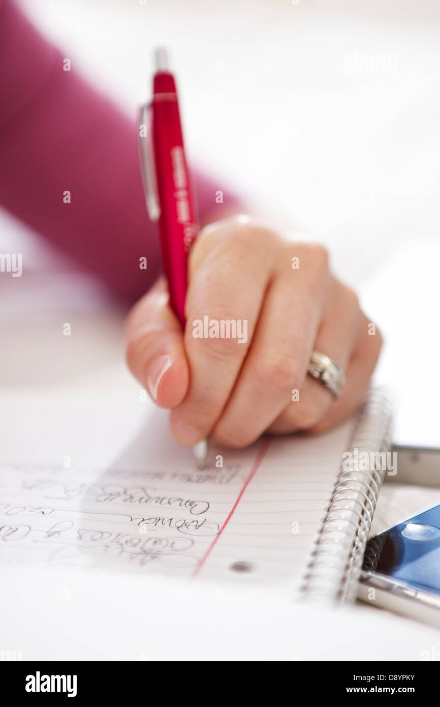 Close-up of womans hand writing on notebook Stock Photo - Alamy