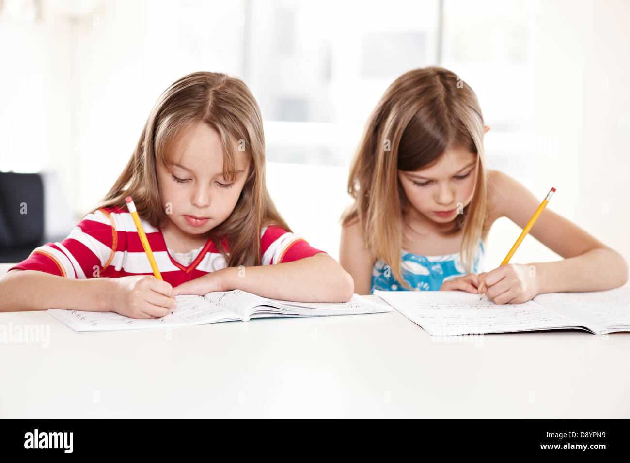 Two girls doing homework Stock Photo - Alamy