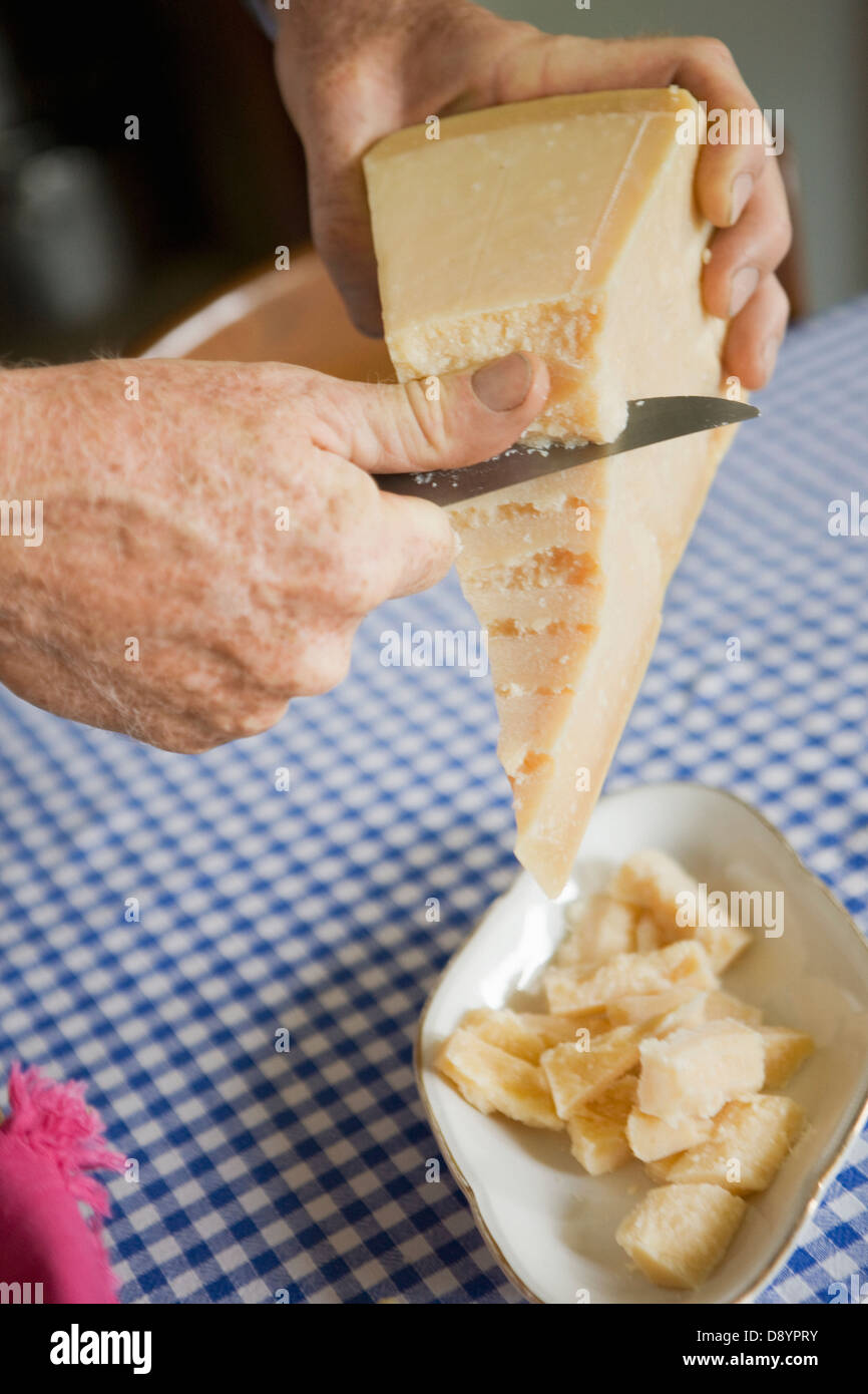 Hand cutting parmesan cheese Stock Photo - Alamy