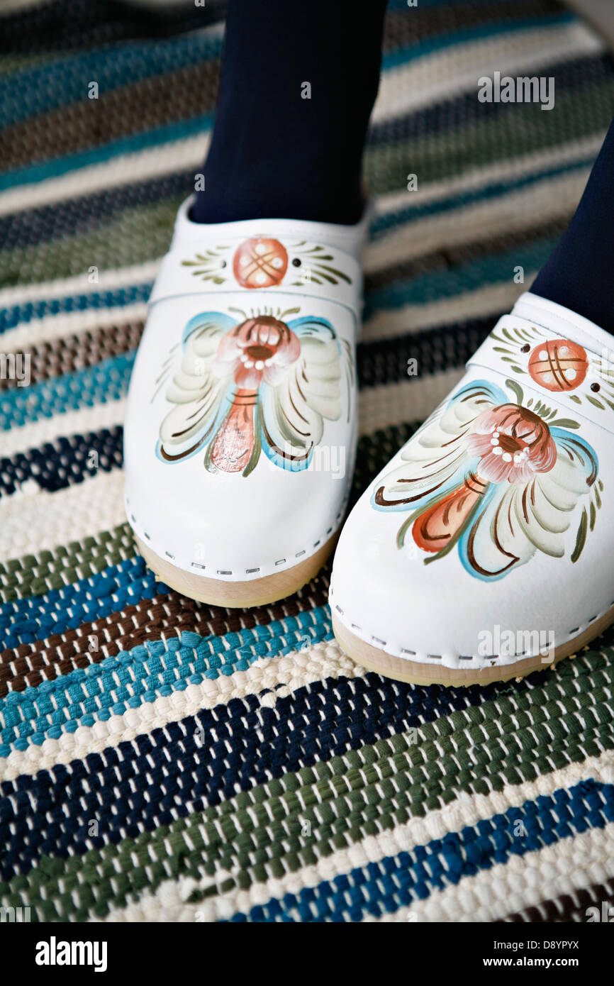 Childs clogs with floral pattern on striped rug Stock Photo - Alamy
