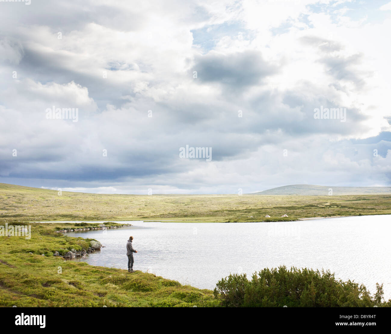 Man fishing at lakeside Stock Photo - Alamy