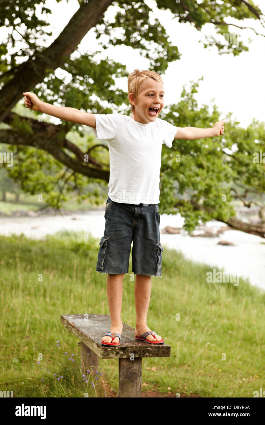 Boy standing on bench Stock Photo - Alamy
