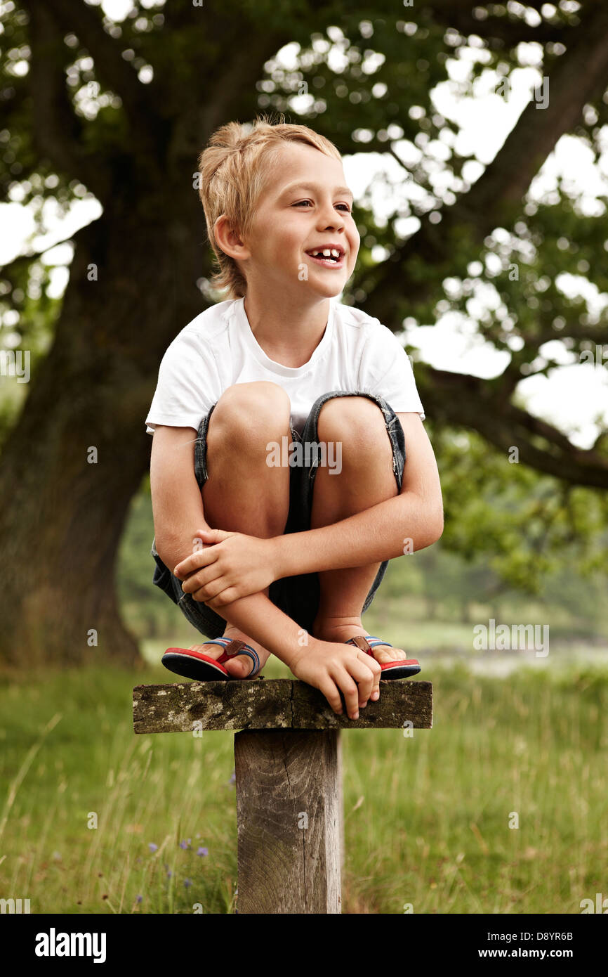 Boy sitting on bench Stock Photo - Alamy
