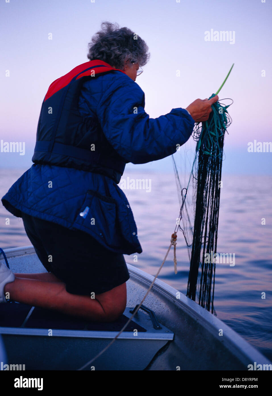 A woman putting a fishing net in the water Stock Photo - Alamy