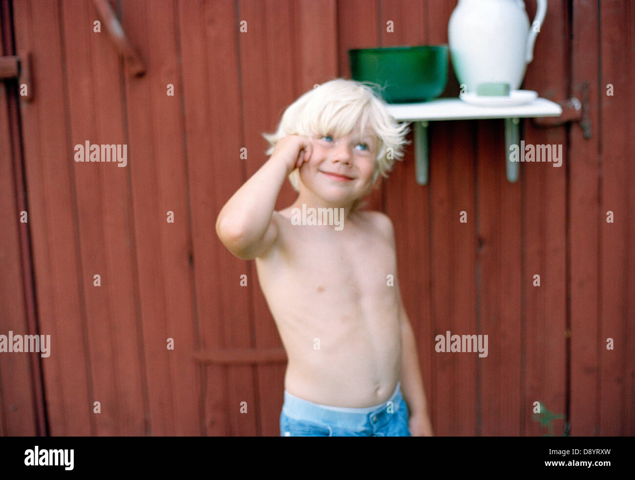 A boy in front of an outhouse Stock Photo - Alamy