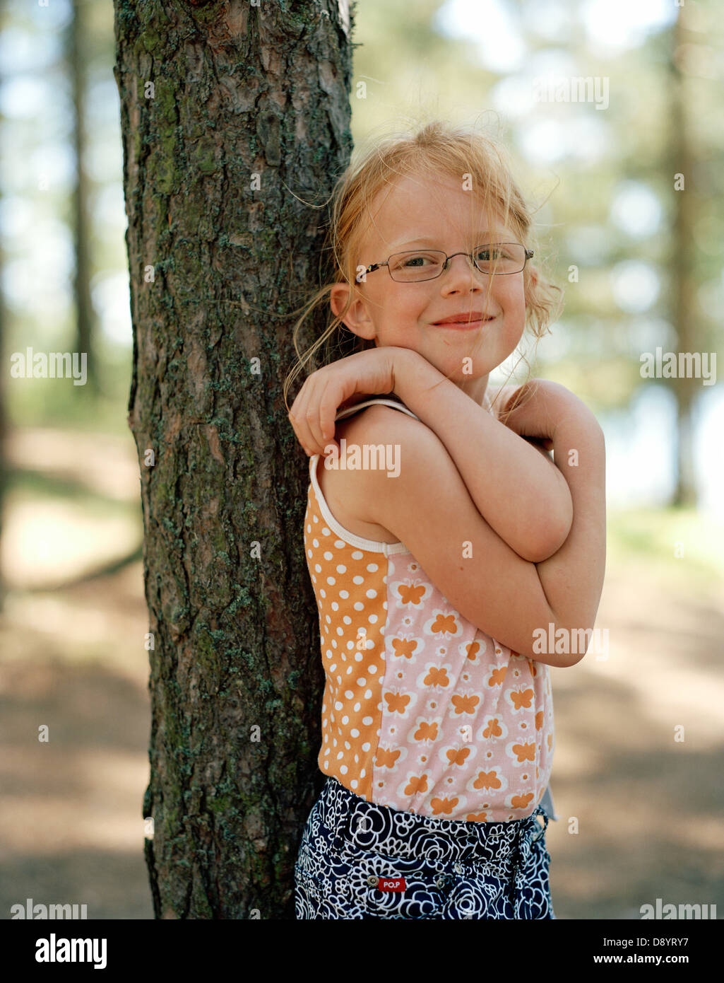 A smiling girl next to a tree Stock Photo - Alamy