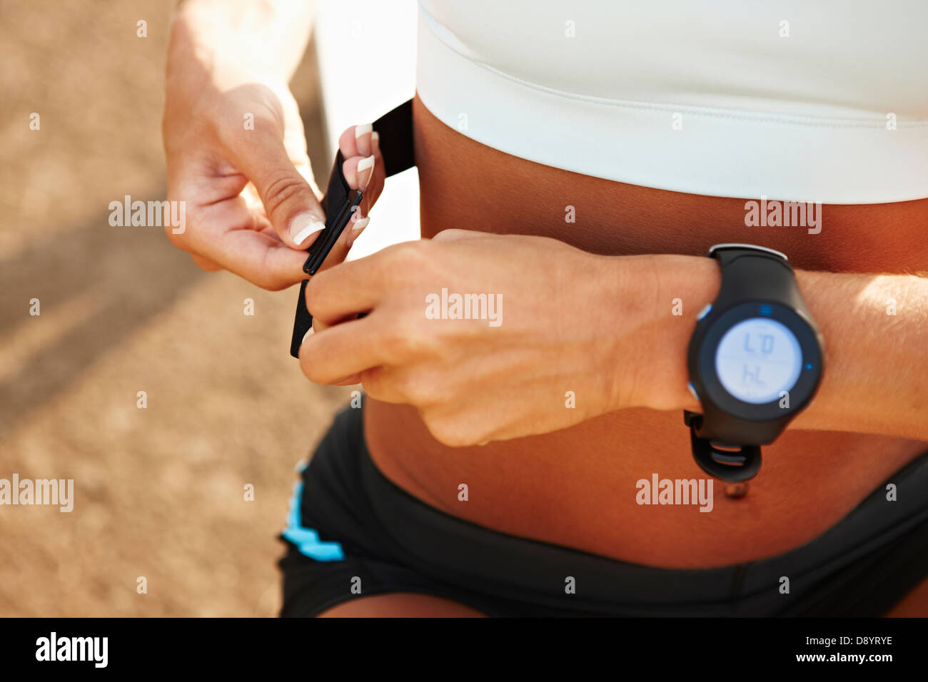 Female runner attaching pulse trace meter on waist Stock Photo - Alamy