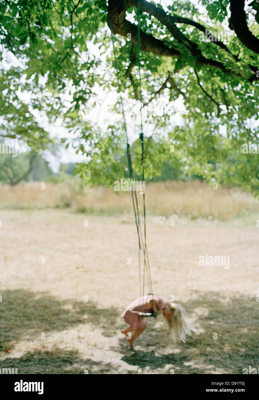 Girl playing with a swing hanging from a tree Stock Photo - Alamy