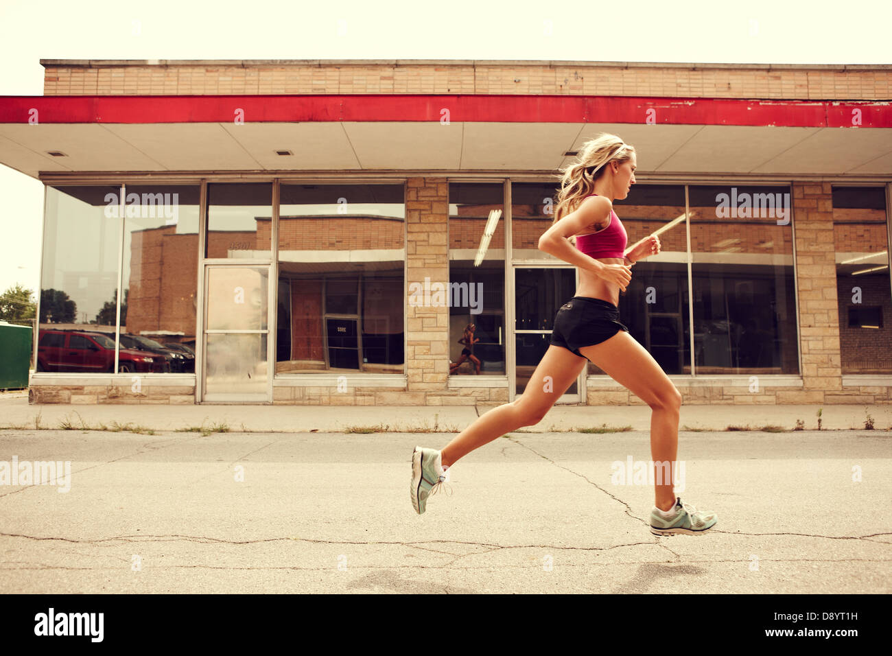 Woman jogging in street Stock Photo - Alamy