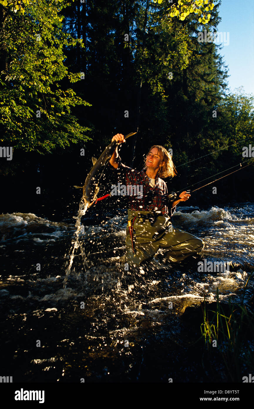 A woman catching a fish Stock Photo - Alamy