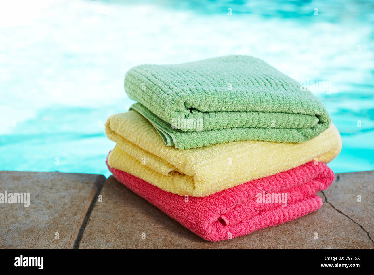 Stack of towels at poolside Stock Photo - Alamy