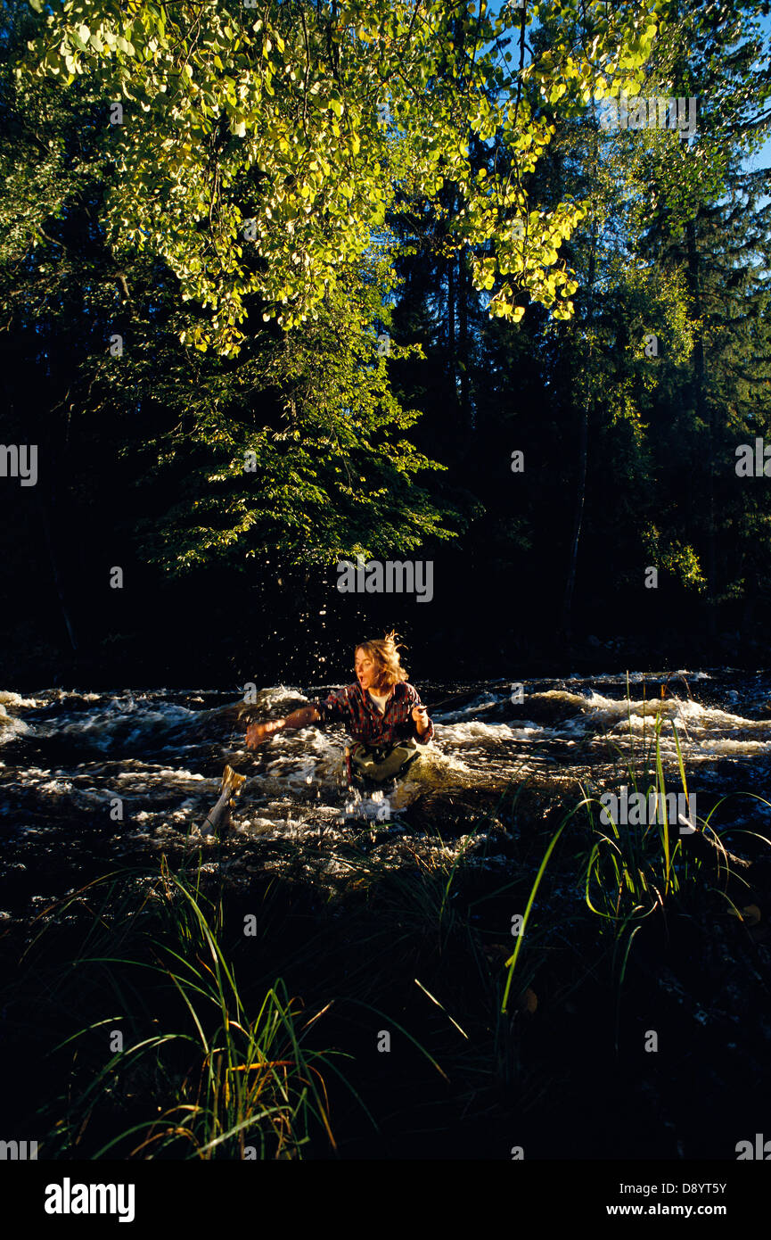 A woman catching fish in a river Stock Photo - Alamy