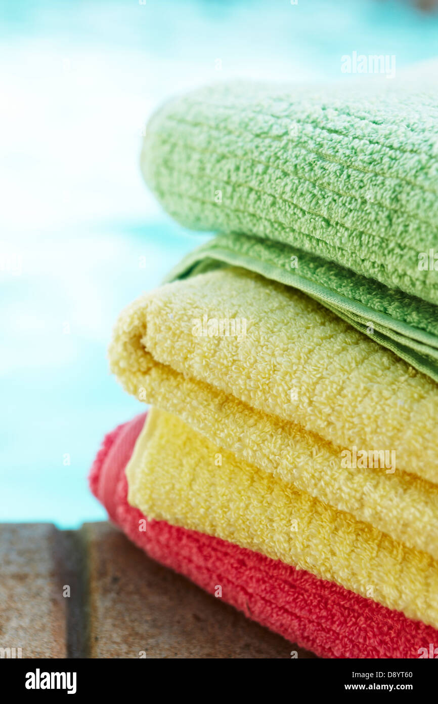 Stack of towels at poolside Stock Photo - Alamy