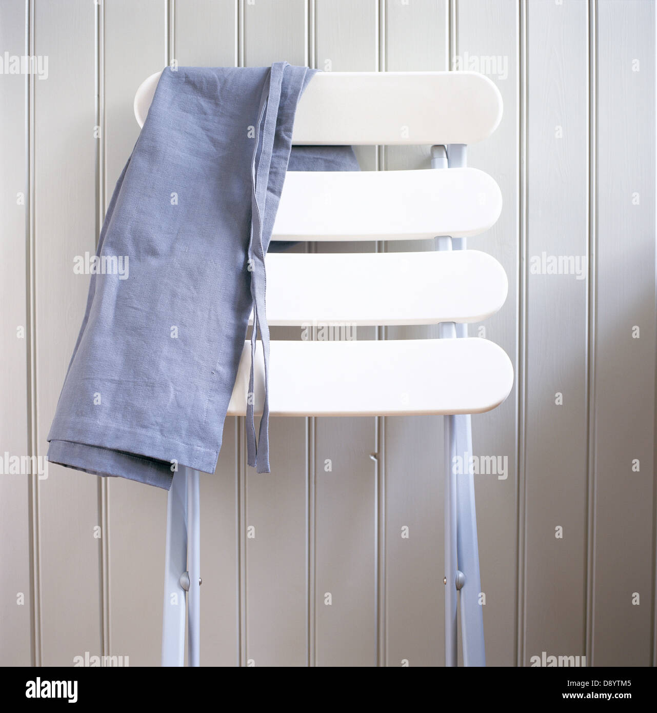 A kitchen apron hanging on a chair Stock Photo - Alamy