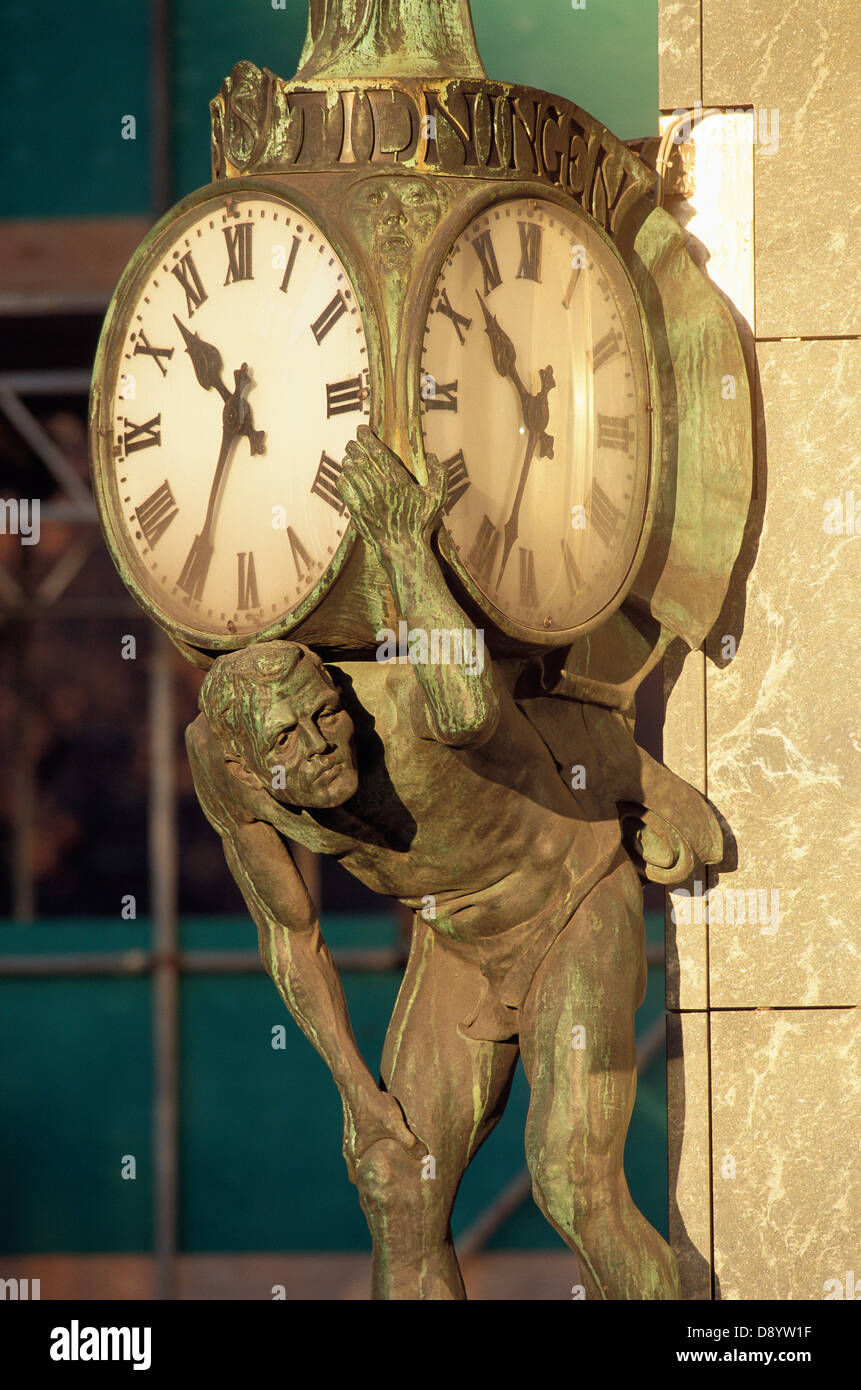 A sculpture of a man carrying a clock on his back Stock Photo - Alamy