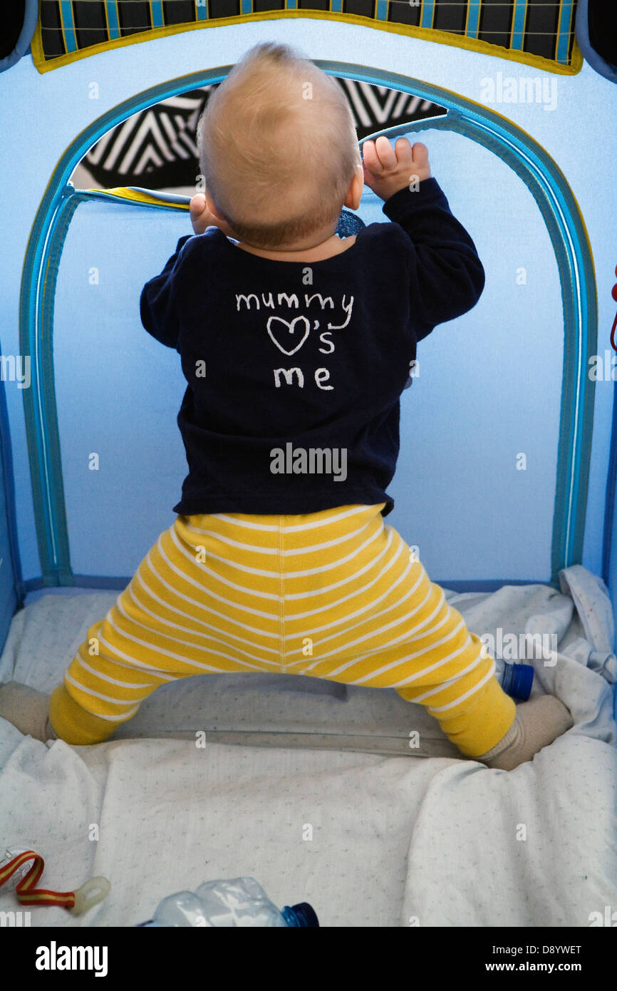 Baby standing up in a bed, Sweden Stock Photo - Alamy