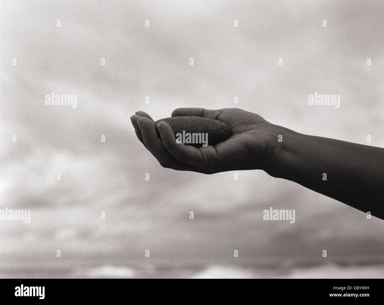 A hand holding a stone Stock Photo - Alamy