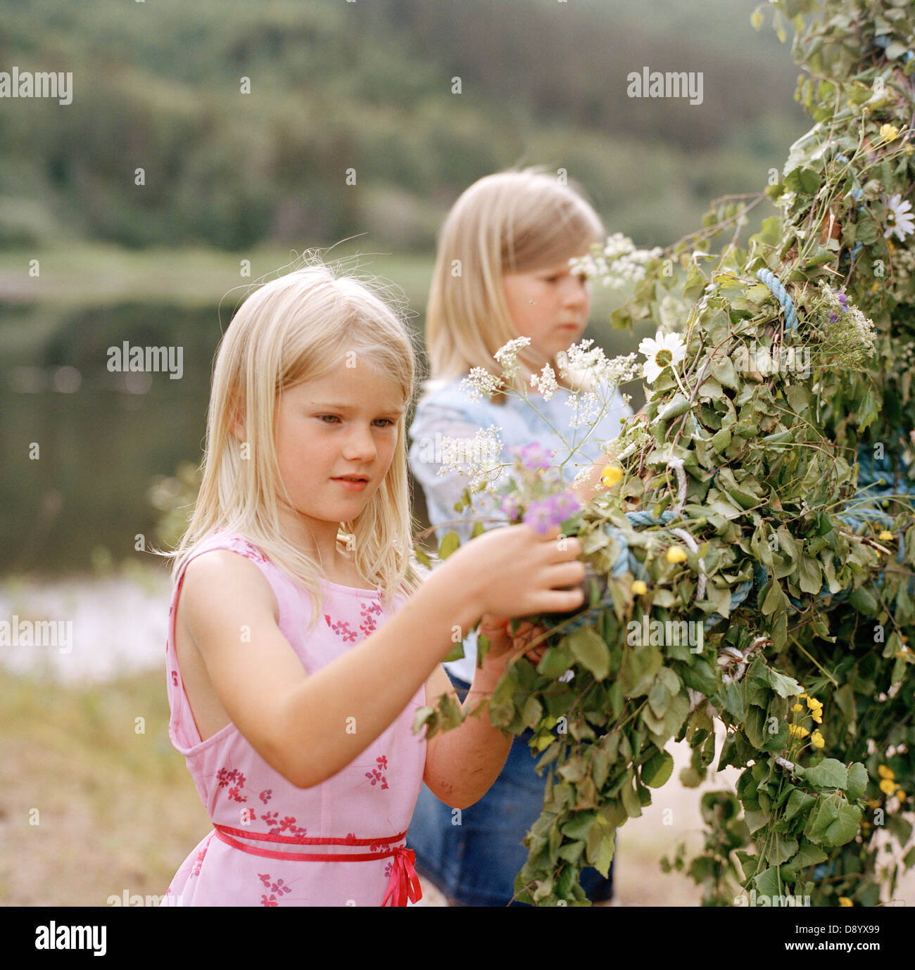 Two girls decorating the maypole for midsummer, Sweden Stock Photo - Alamy
