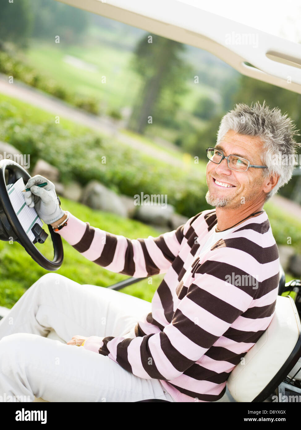 A man driving a golf cart Stock Photo - Alamy