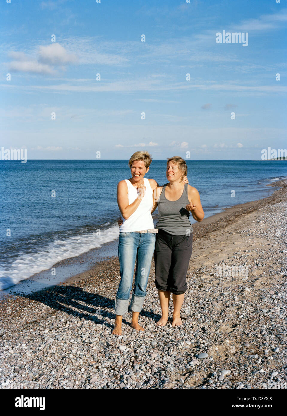 Two laughing women on a beach Stock Photo - Alamy