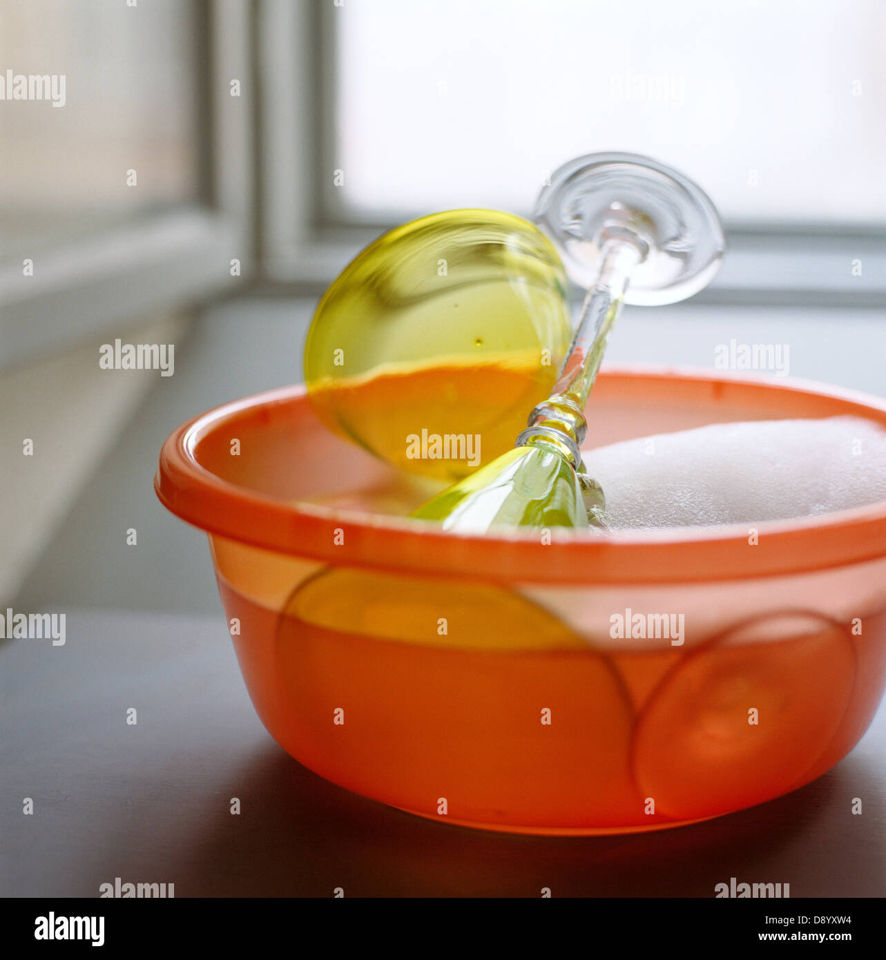 Red washing-up bowl with wine glasses Stock Photo - Alamy