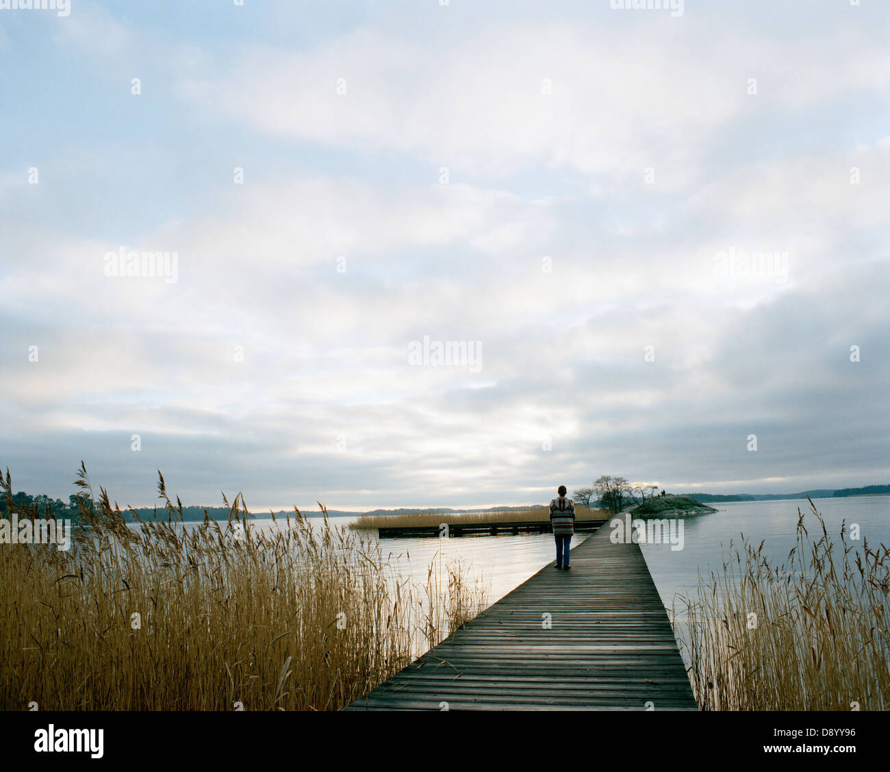A woman walking on a jetty Stock Photo - Alamy