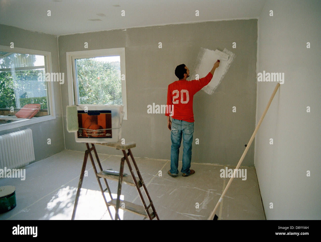 A man painting a wall Stock Photo - Alamy