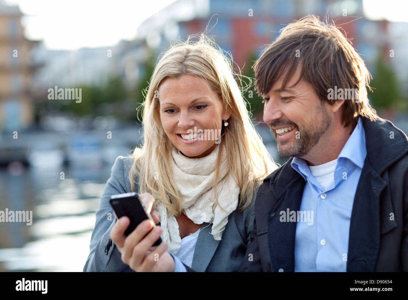 Couple using cell phone together Stock Photo - Alamy