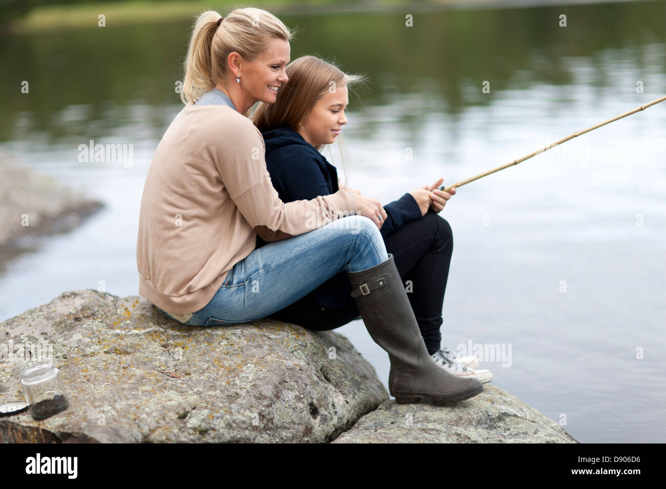 Daughter and mother fishing at lake Stock Photo - Alamy