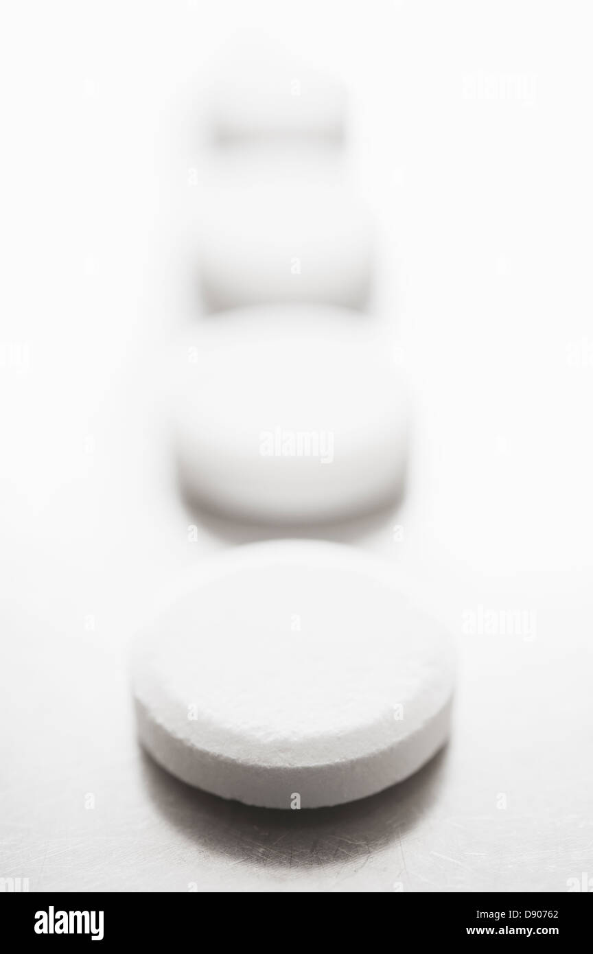 Pills in row on white background Stock Photo - Alamy