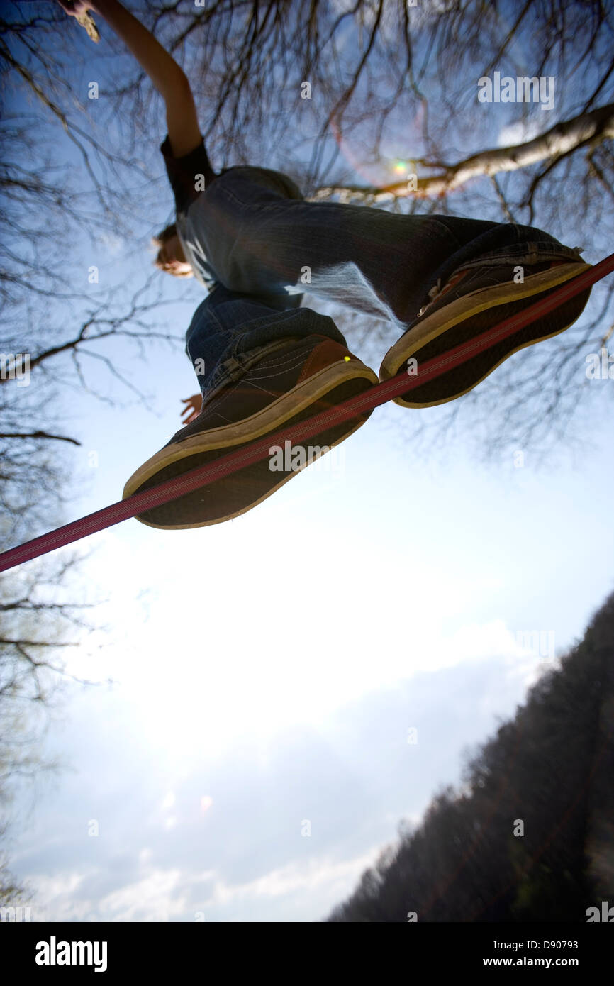 A young man balancing on a rope Stock Photo - Alamy