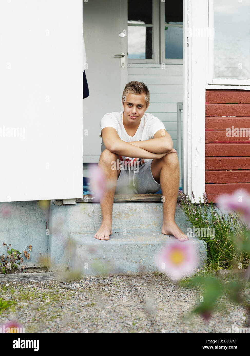 Teenage boy sitting on porch Stock Photo - Alamy